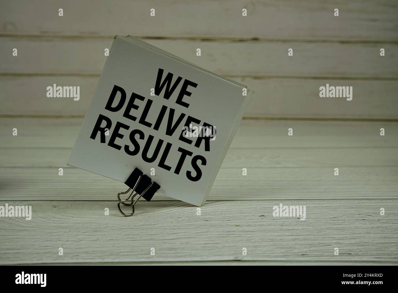We Deliver Results text message write on sticky note on wooden ...