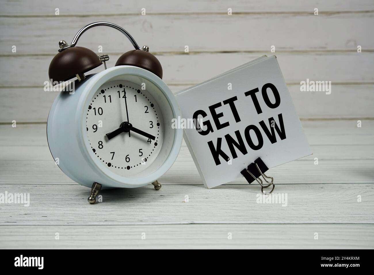 Get to Know text message on sticky note with alarm clcok on wooden ...