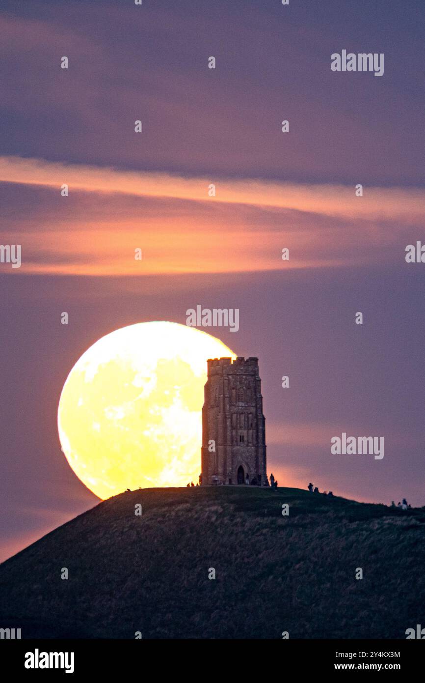 People gather as the supermoon rises over St Michael's Tower, atop ...