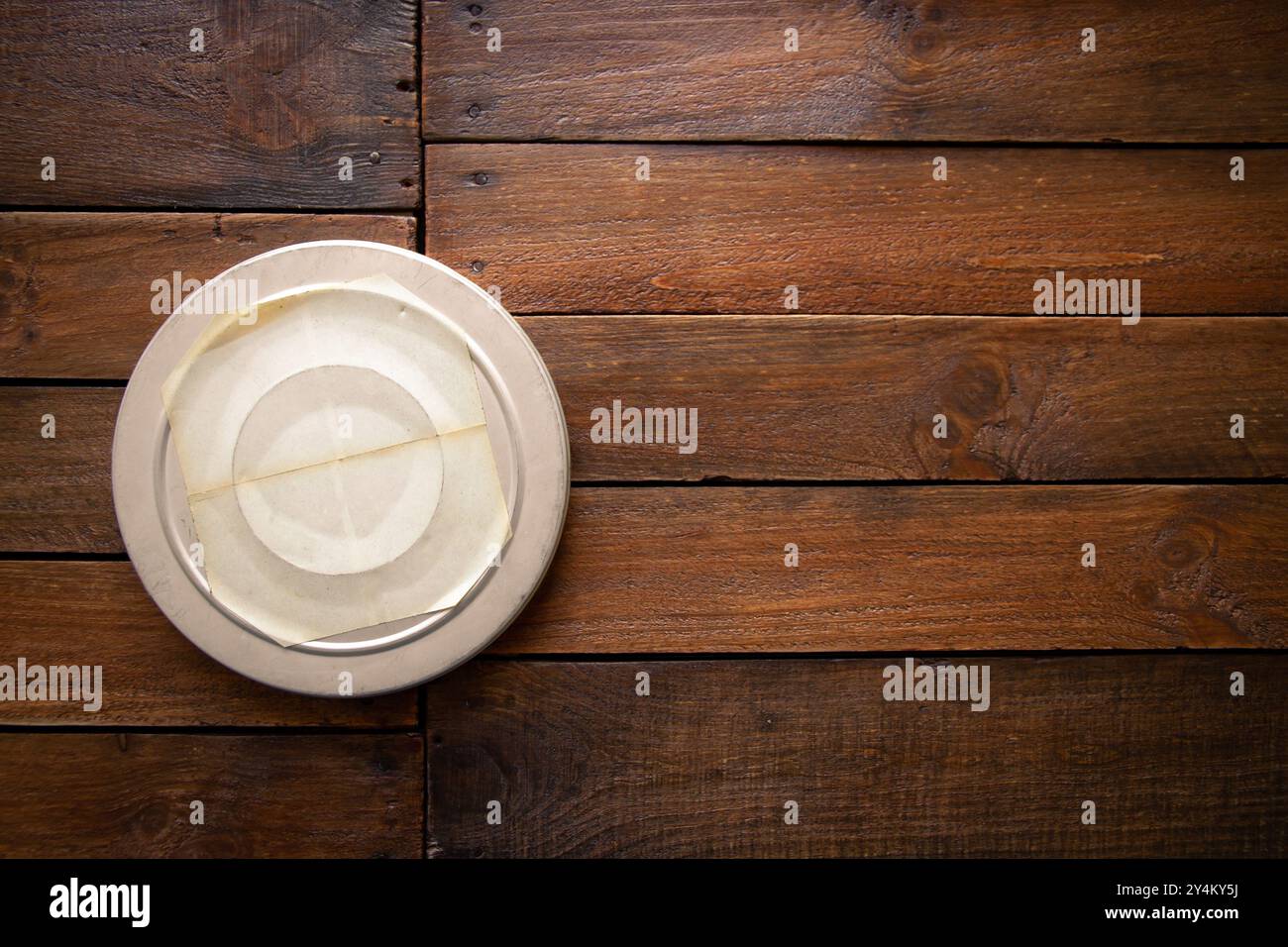 Old cinema film reel box on a rustic vintage wooden board. Blank label ...