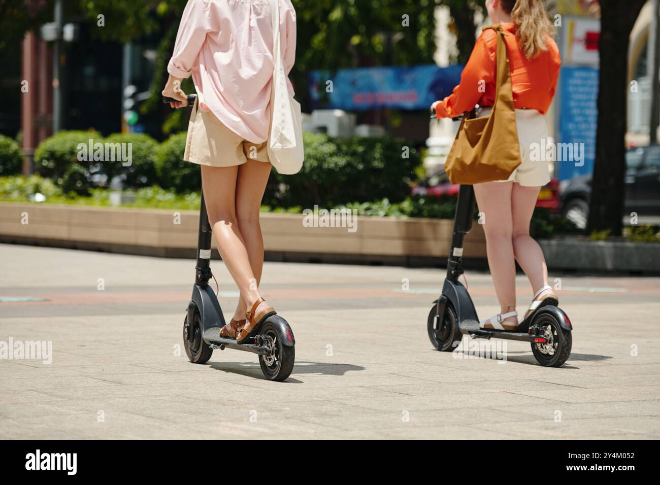 Riding Electric Scooters Through Urban Landscape Stock Photo - Alamy