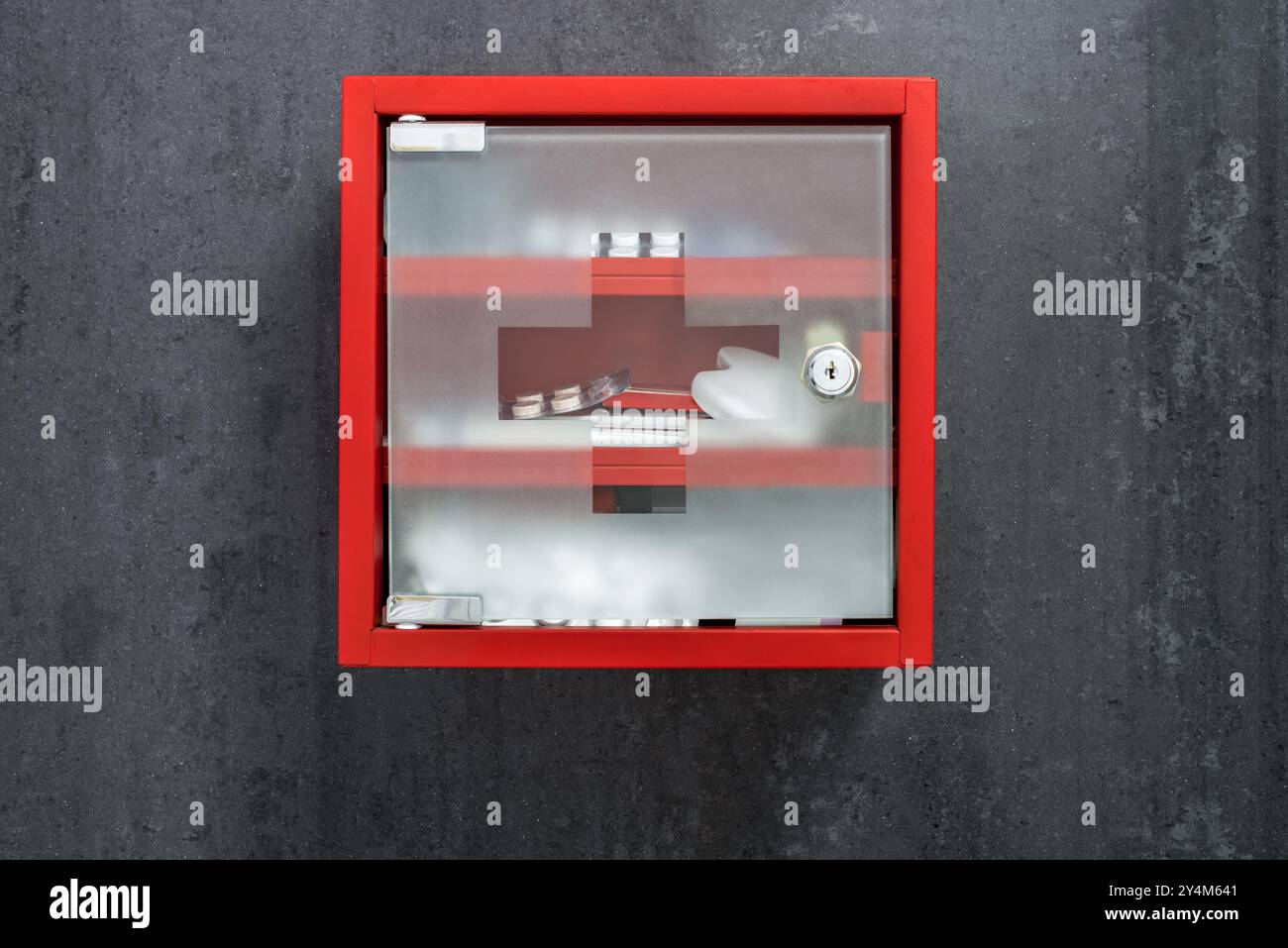Closed Red Metal Medical Care Box Full Of Drugs Hanging On A Dark Gray ...