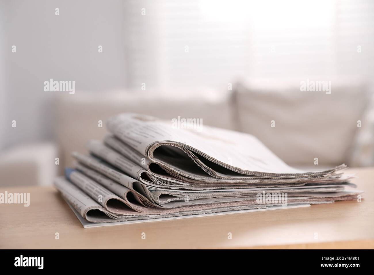 Stack of newspapers in different languages on table indoors Stock Photo ...