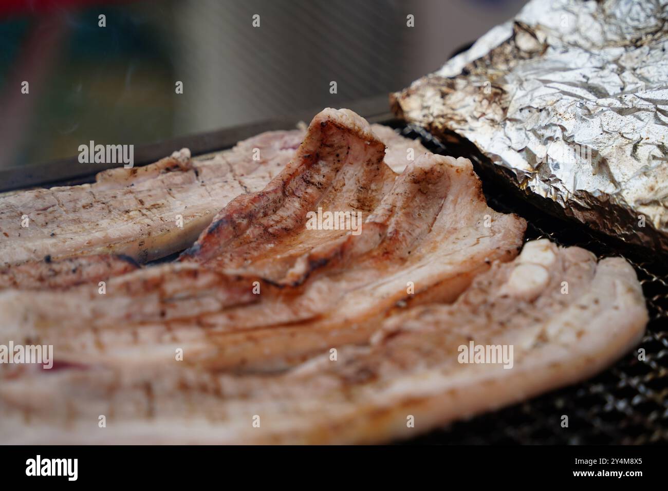 Close-up of pork belly being grilled on a charcoal grill Stock Photo ...