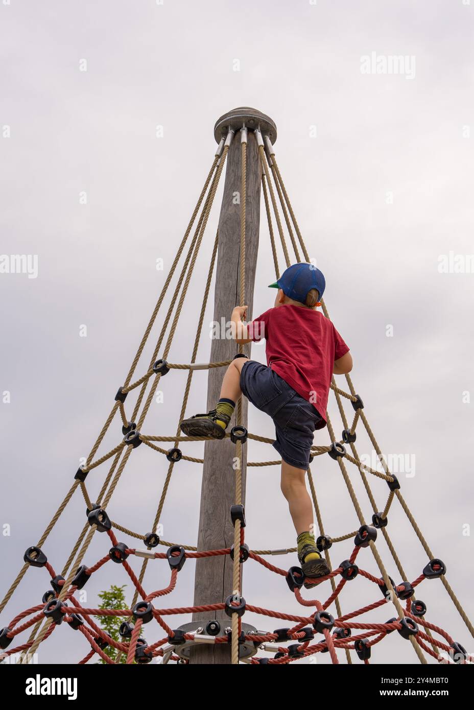Little boy playing outside, climbing rope ladder. Concept active ...