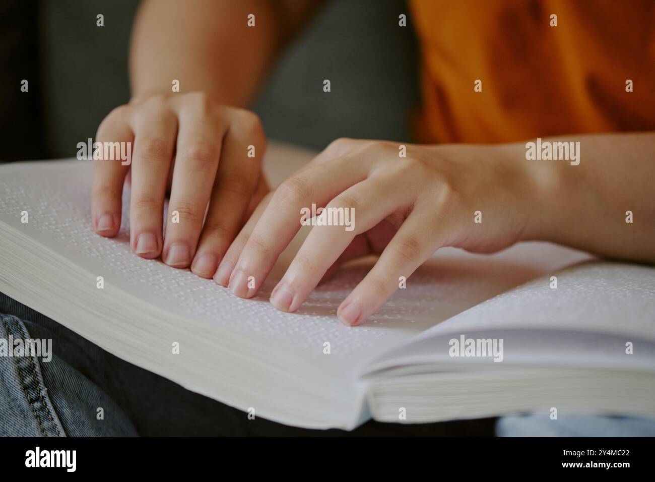 Medium close up of unrecognizable female hands touching Braille books ...