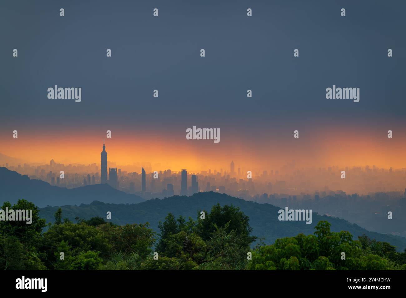 The captivating silhouette of the Taipei skyline is bathed in the warm ...
