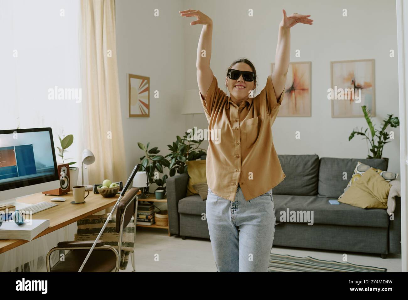 Blind woman smiling widely and dancing while hanging out alone at home ...