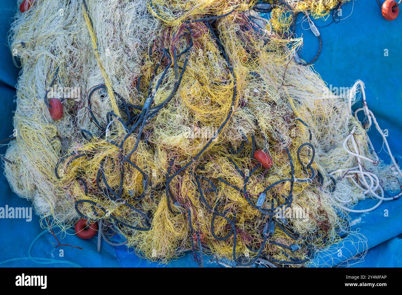 Industrial fishing nets on waterfront. A pile of fishing nets lying on ...