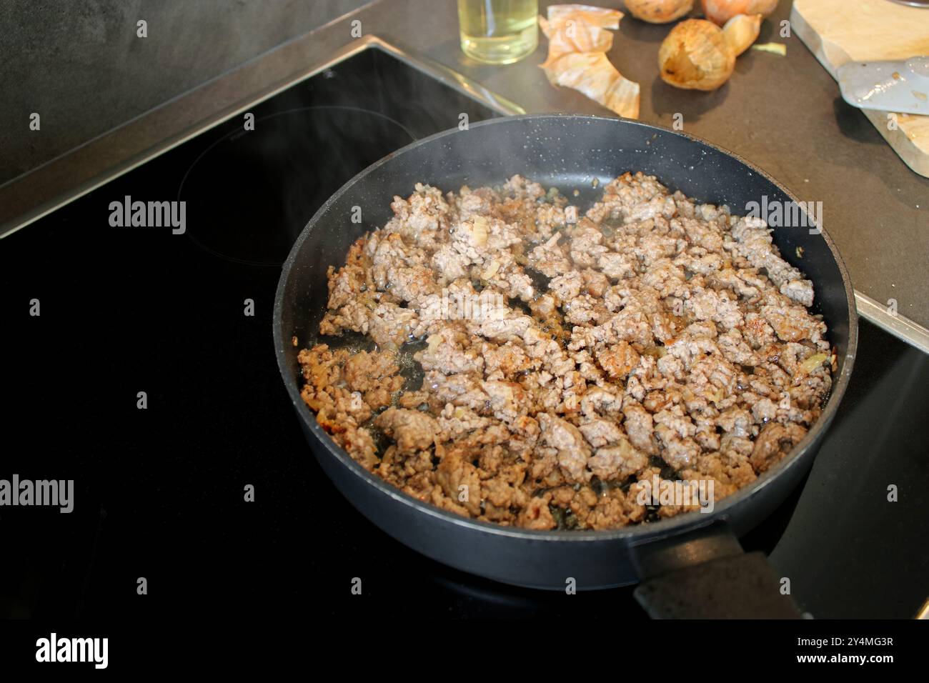 Close up cooked ground beef meat frying in a black pan in the kitchen ...