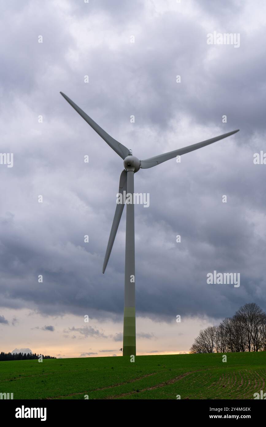 Windmill against a gray sky stands in field. Rural landscape. Wind ...