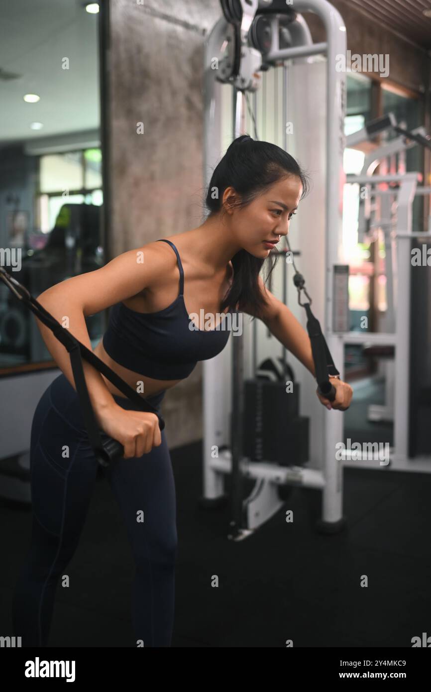 Attractive athletic woman focusing on a chest fly exercise in a gym ...