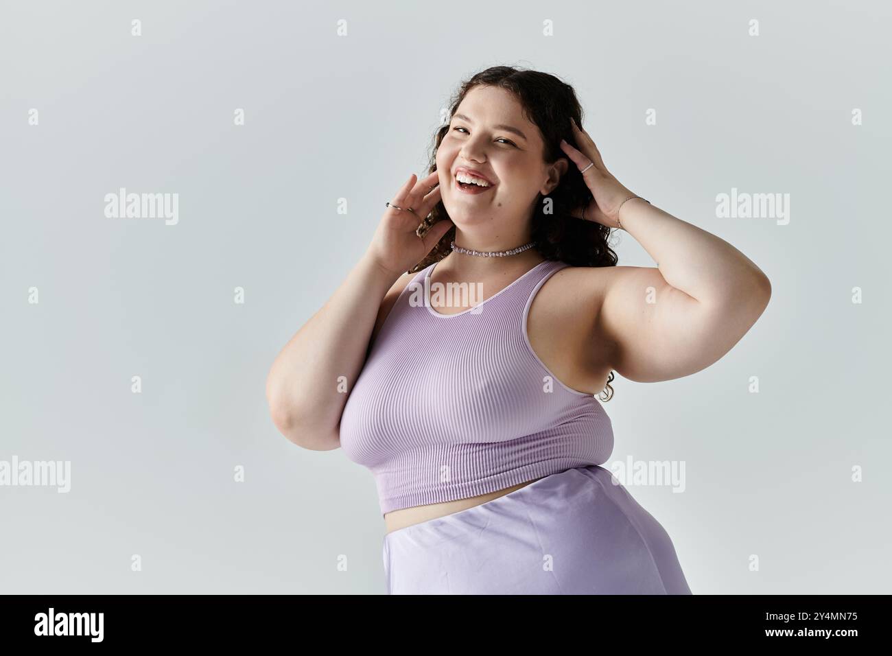 An elegant plus size woman playfully poses, showcasing her confidence ...