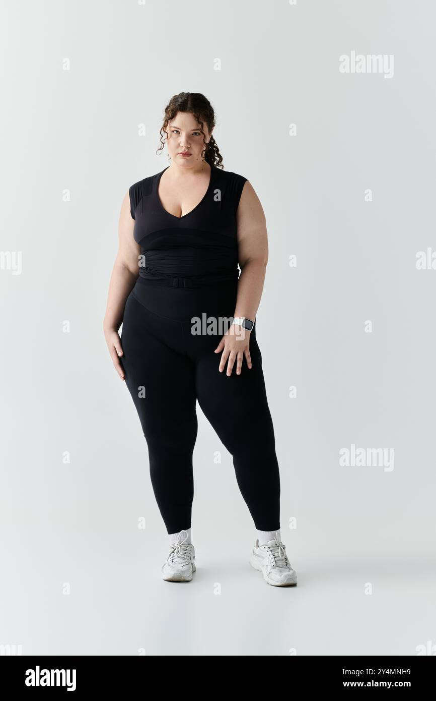 A beautiful plus size woman poses gracefully in fitted black attire ...