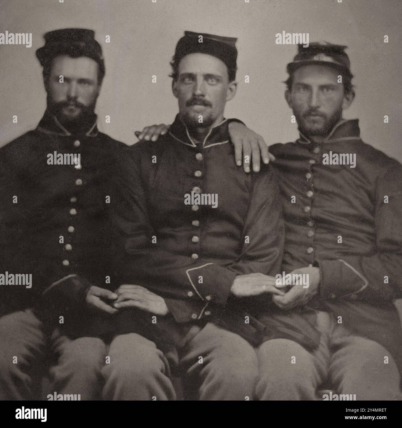 Three unidentified Union soldiers are seated together, dressed in ...