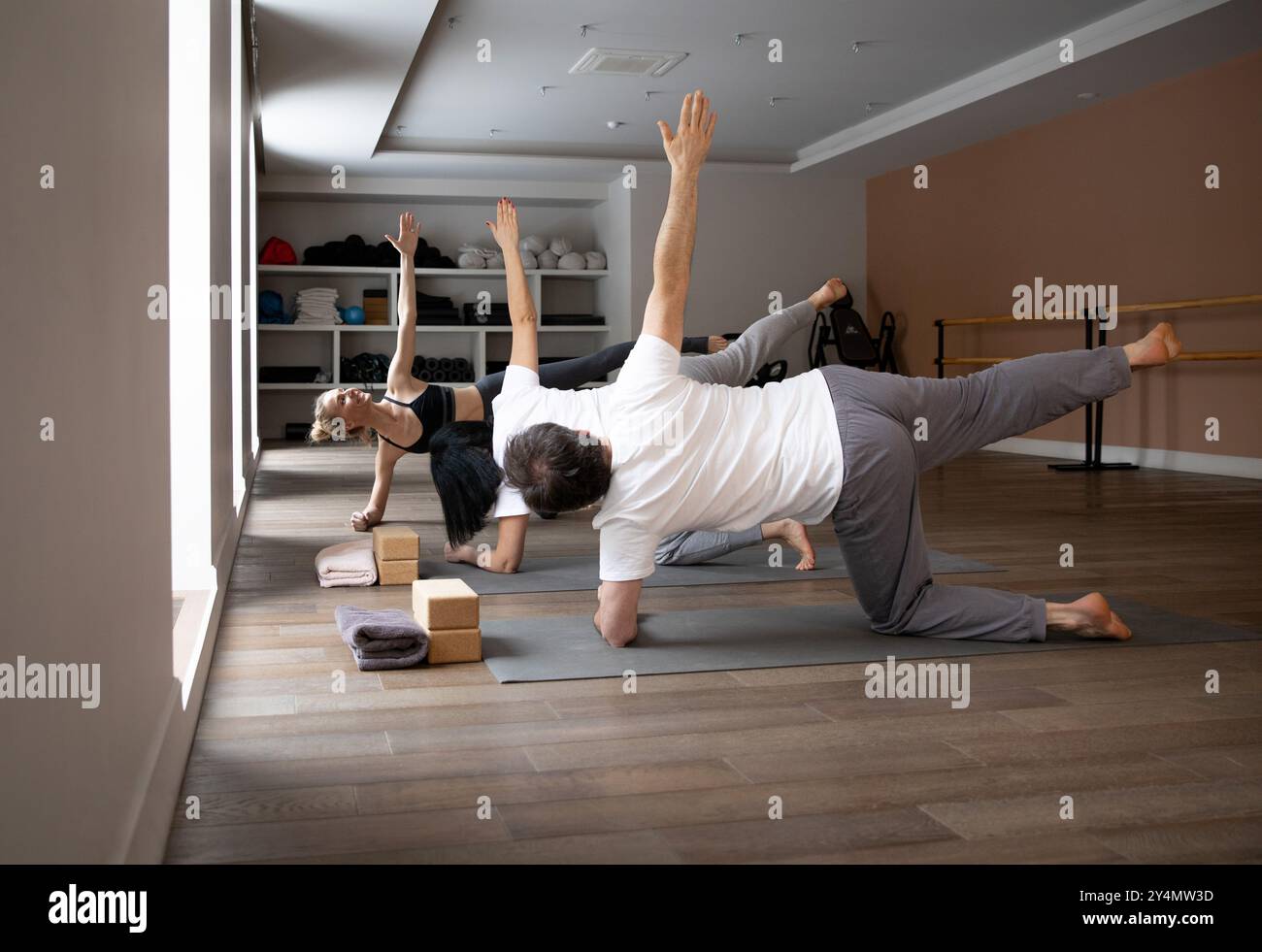 Female yoga and pilates trainer conducts group class in a practice room ...