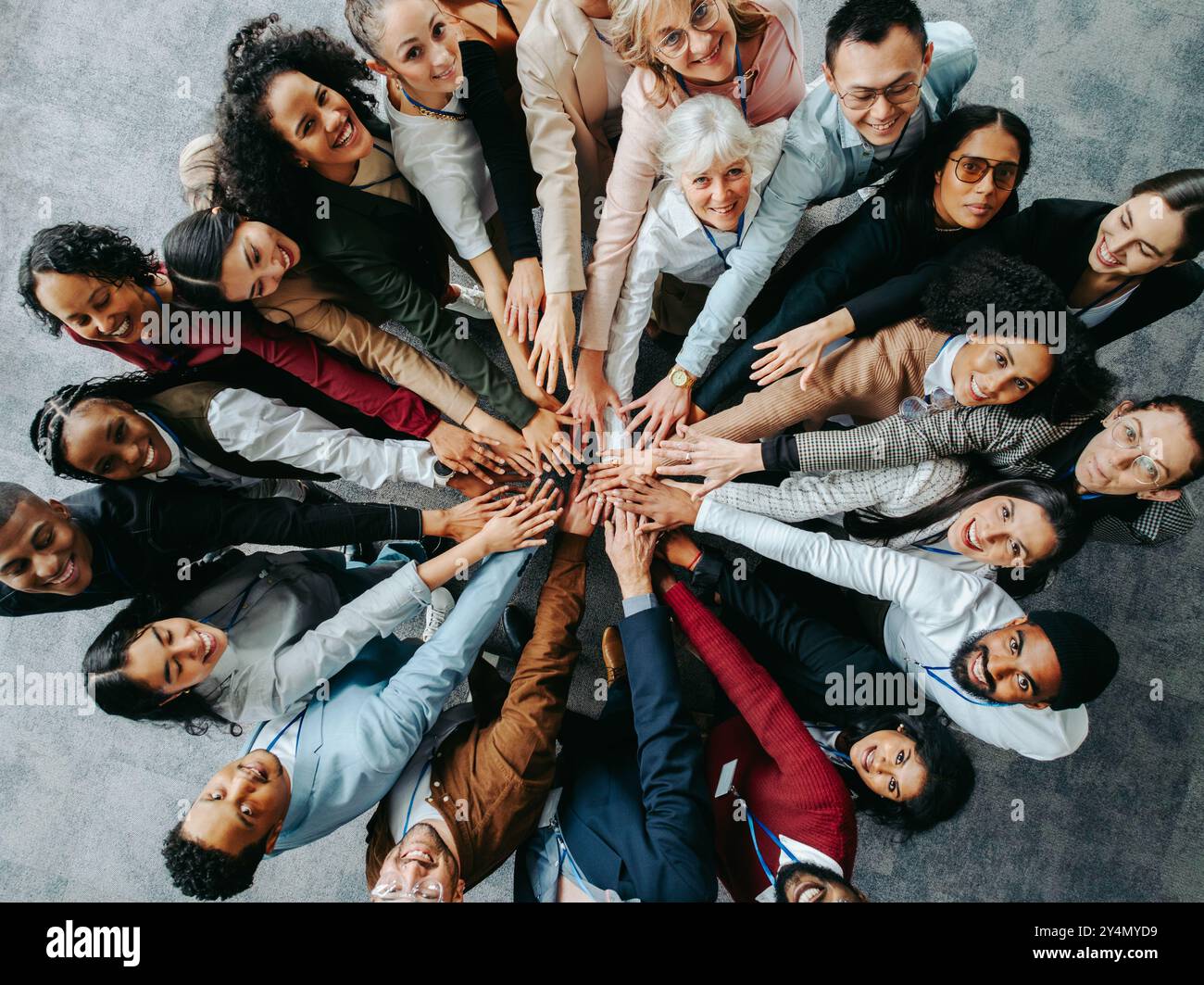 Diverse group of business team members with hands in the middle ...