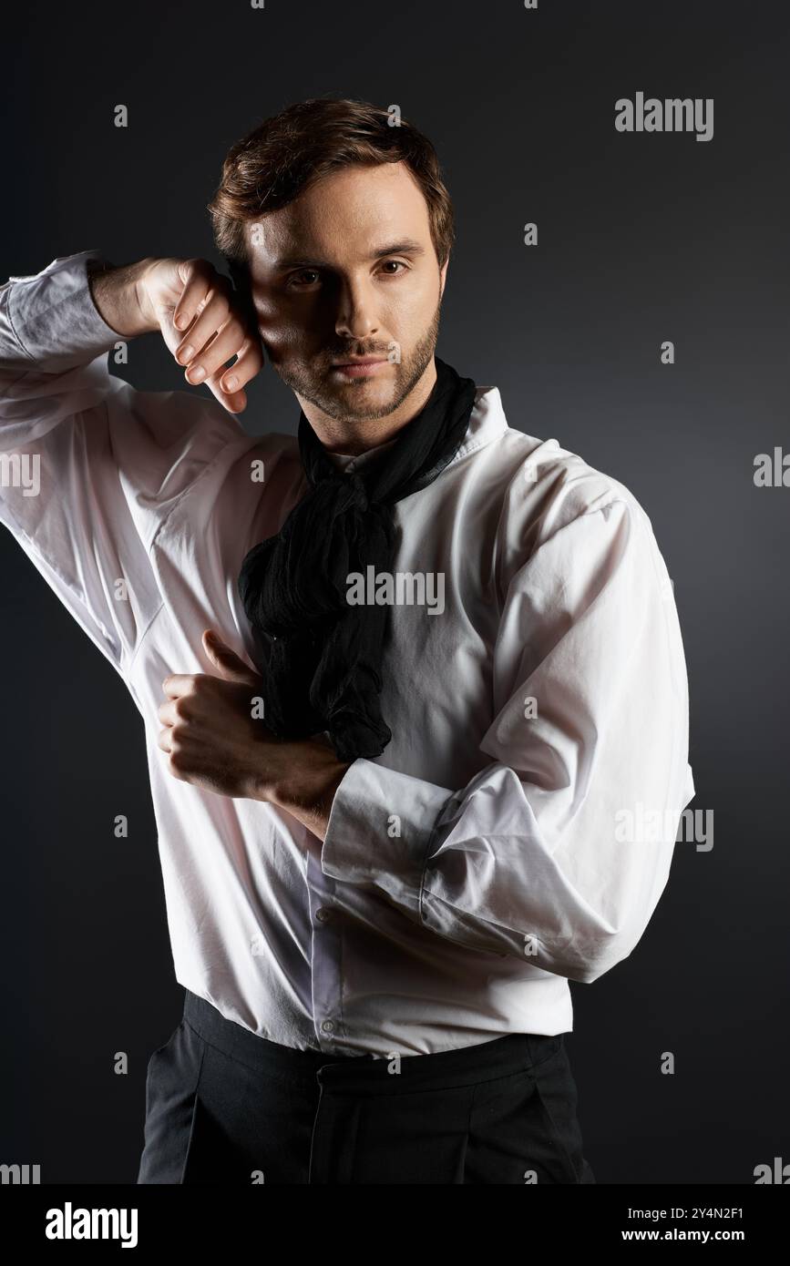 A handsome and stylish man showcases his dandy outfit against a dark ...