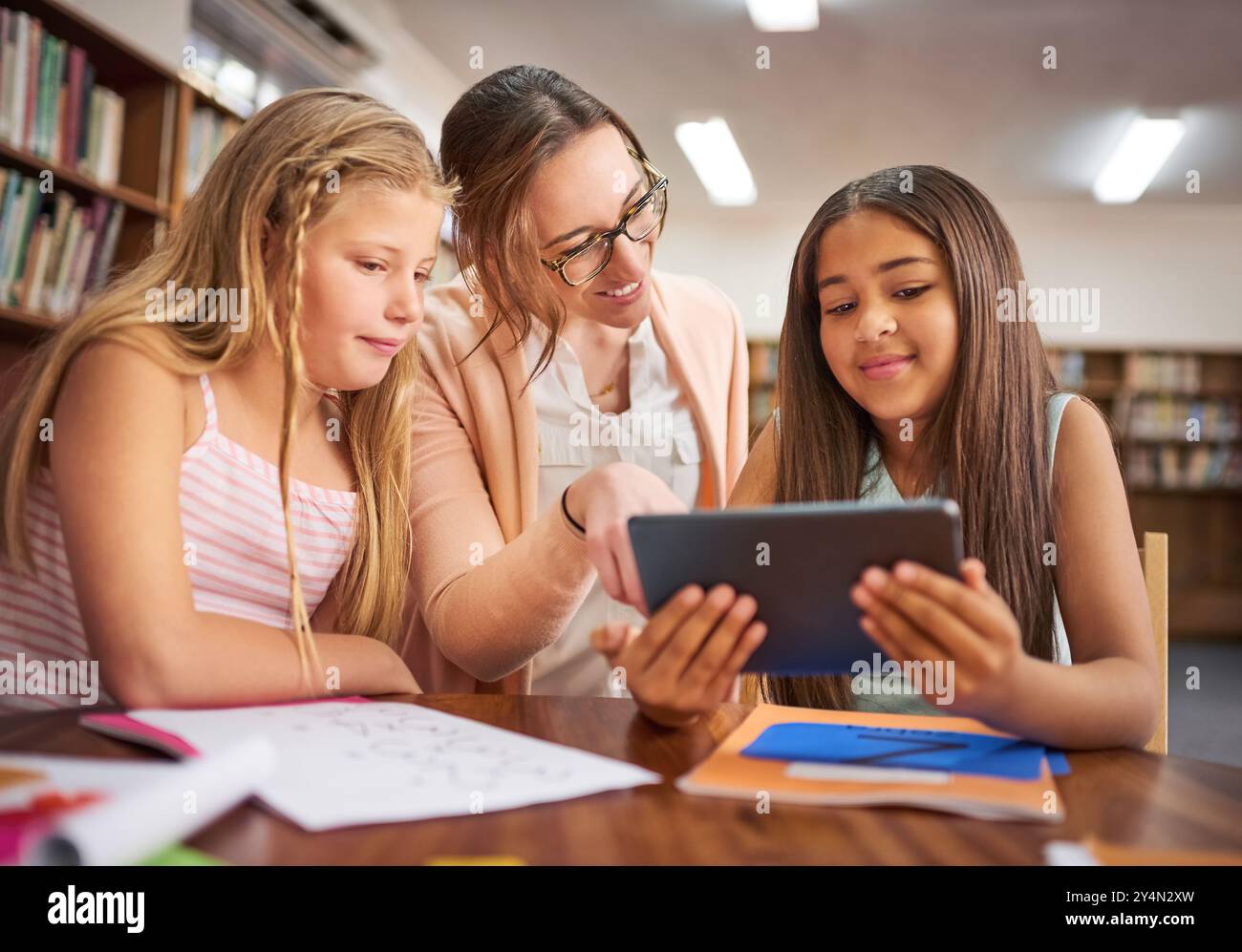 Children, teacher and helping with tablet for education, elearning and ...