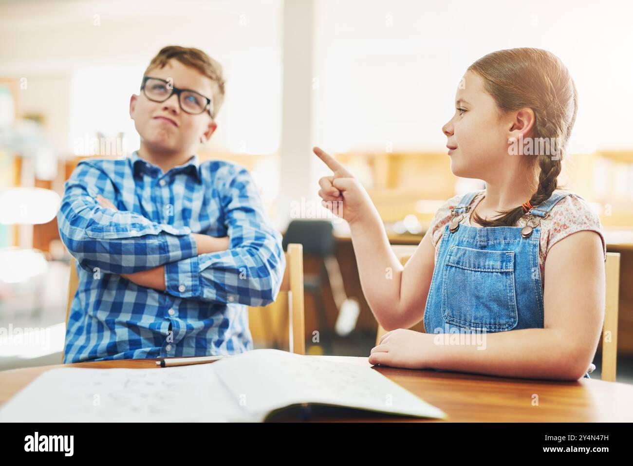 Girl, boy and talking in classroom with books, project and question for ...