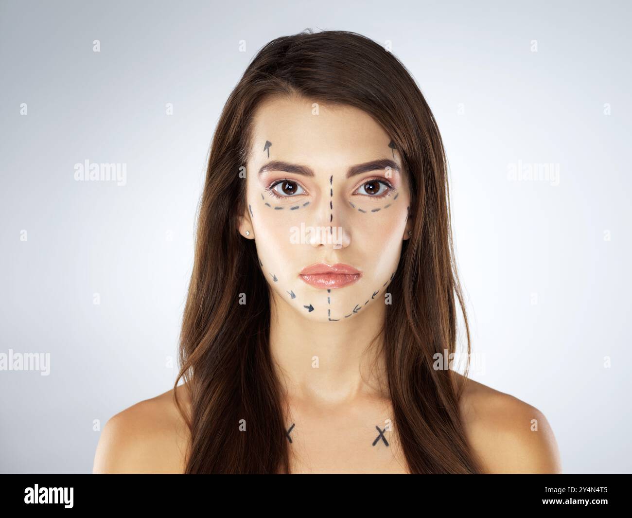 Woman, face and arrow in studio for plastic surgery, chin augmentation ...