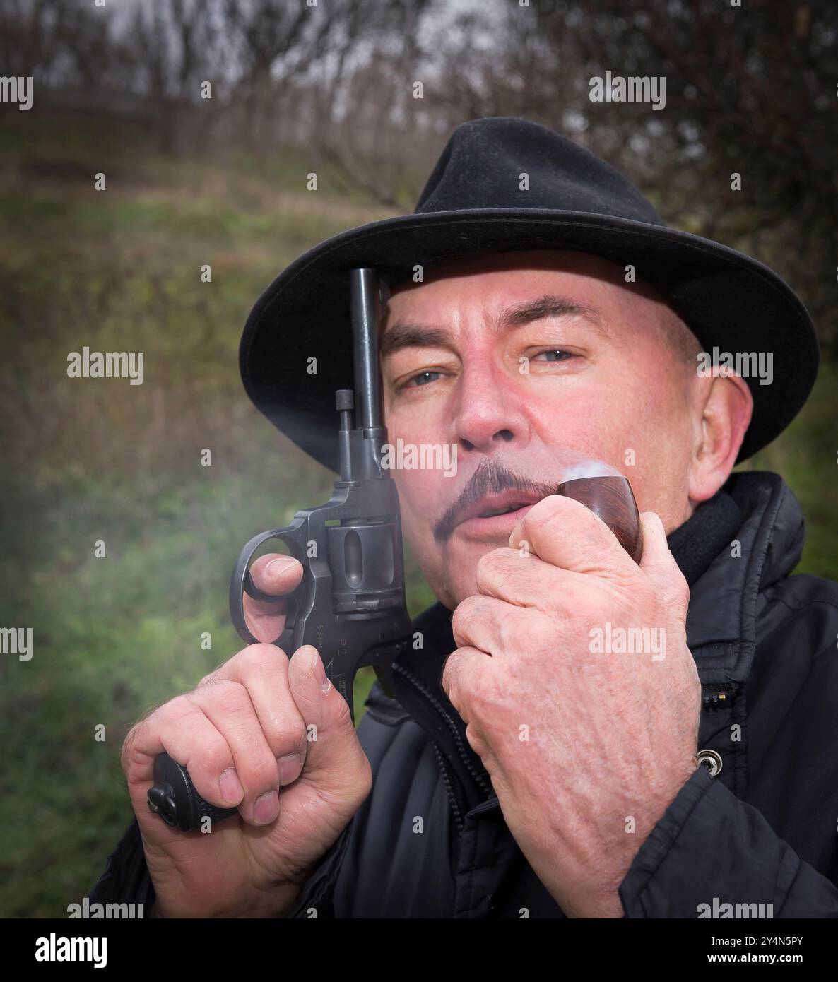 Man with gun system Nagan smoking his pipe Stock Photo - Alamy