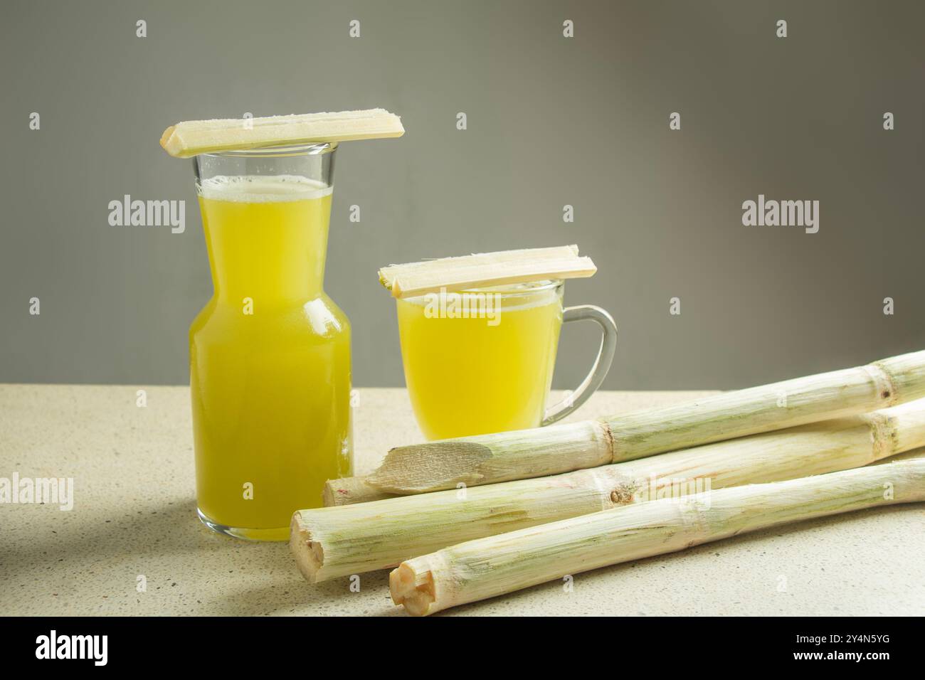 two glasses of sugar cane juice drink on white marble table isolated ...