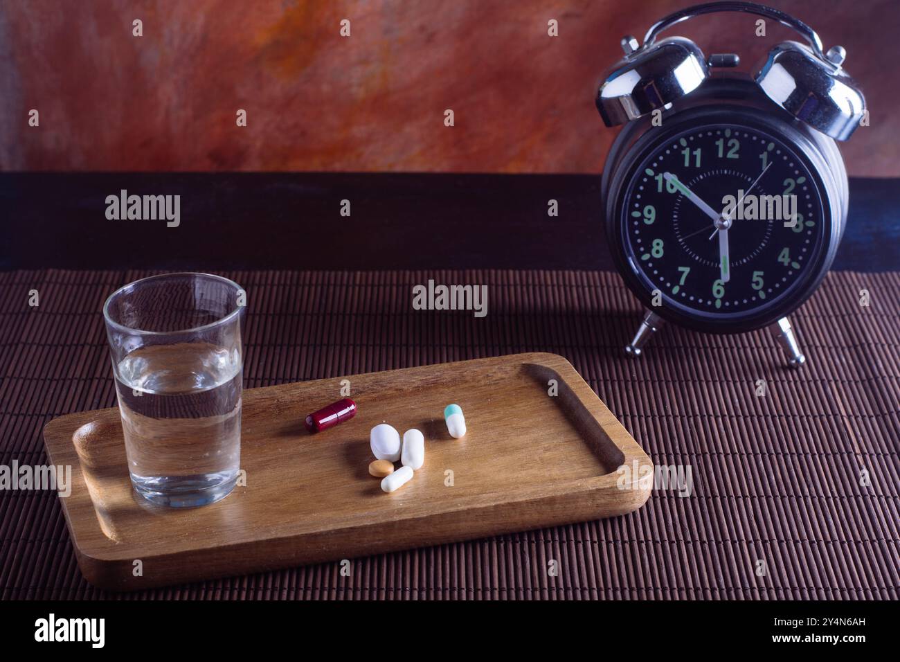 Assorted medication on tray with glass of water and alarm clock Stock ...