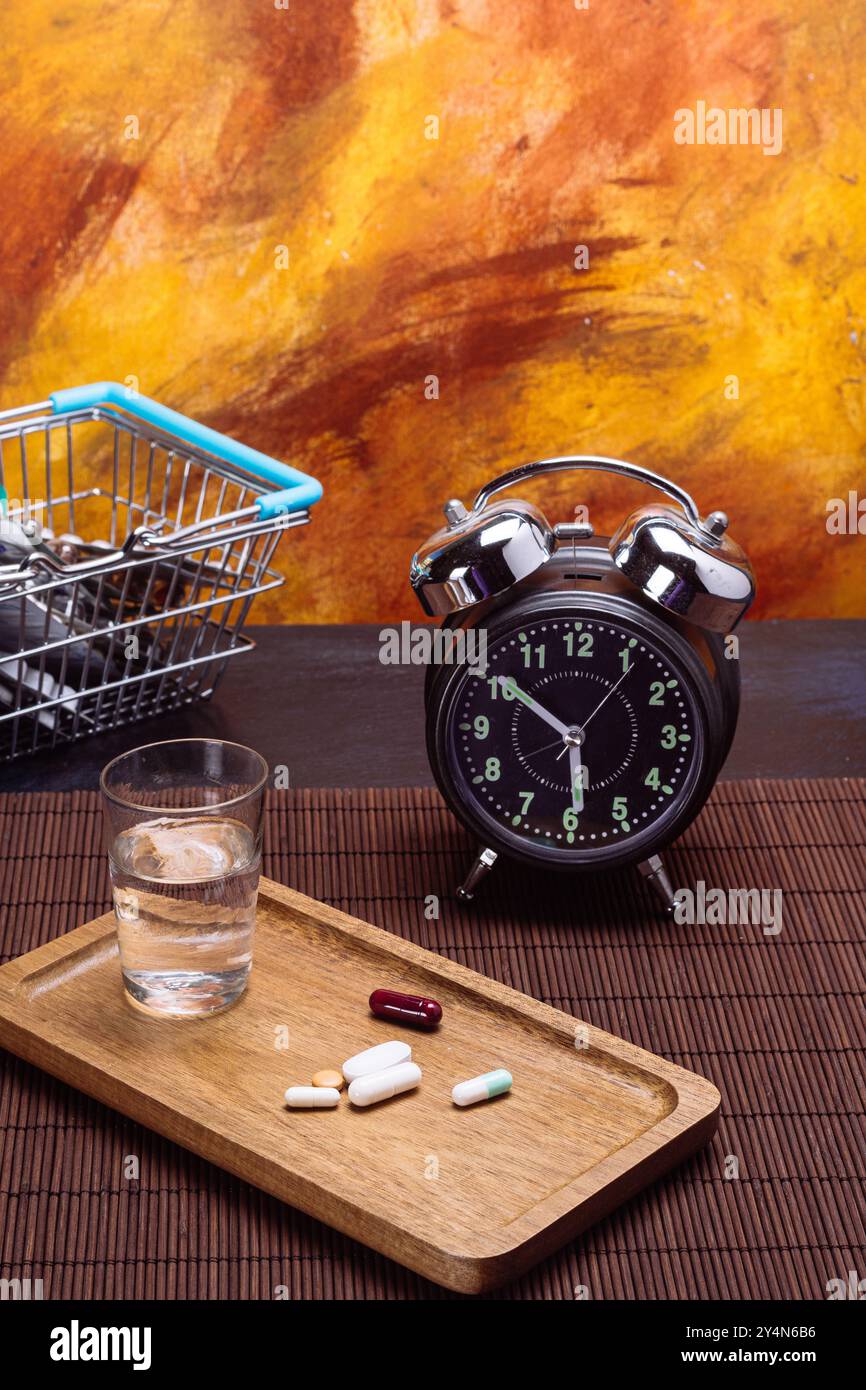 Assorted medication with water, alarm clock, and shopping basket Stock ...