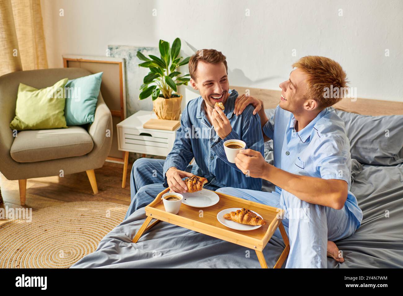 A loving couple shares breakfast together in their pajamas, embracing a ...