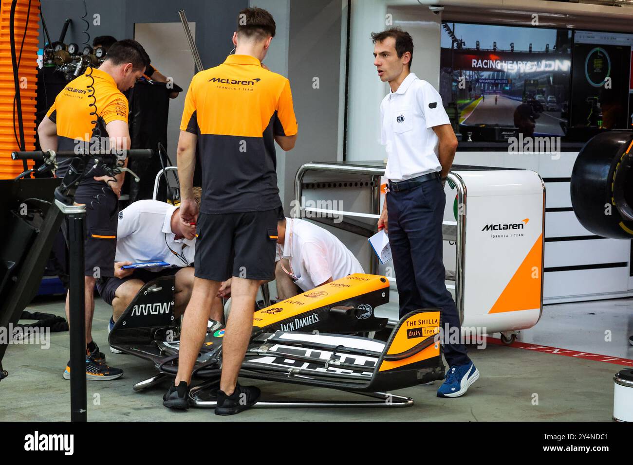 FIA scrutineers check the front wing of the McLaren F1 Team MCL38 ...