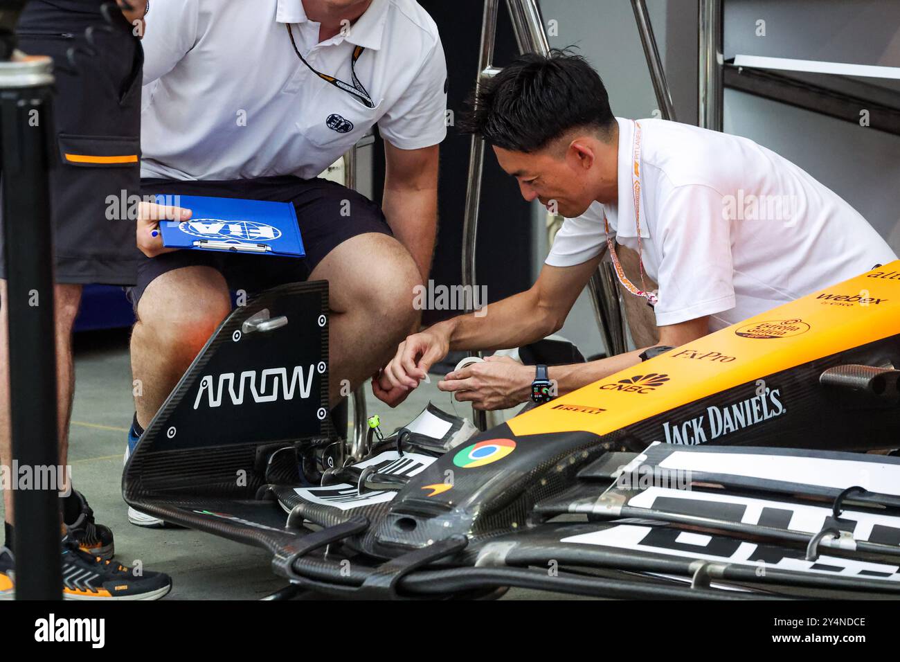 FIA scrutineers check the front wing of the McLaren F1 Team MCL38 ...