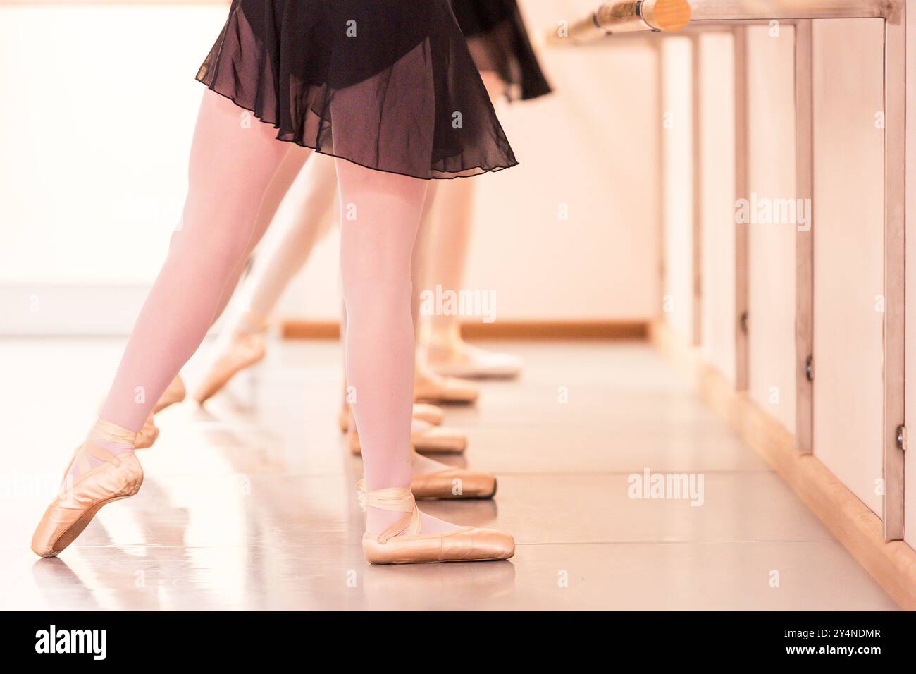 Ballet dancers are practicing their graceful moves in a bright dance ...