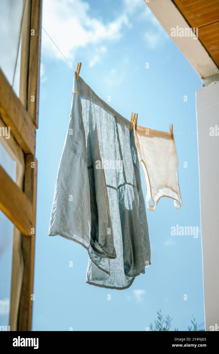 Linen shirt and top air drying on a clothesline in the sun Stock Photo ...