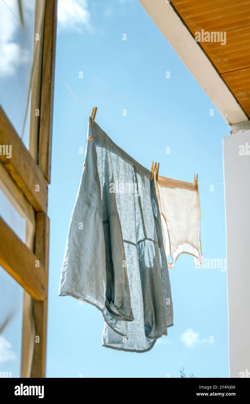 Linen shirt and top air drying on a clothesline in the sun Stock Photo ...