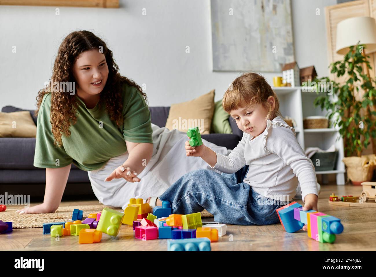 A mother and daughter enjoy quality time playing with vibrant building blocks on the floor Stock ...