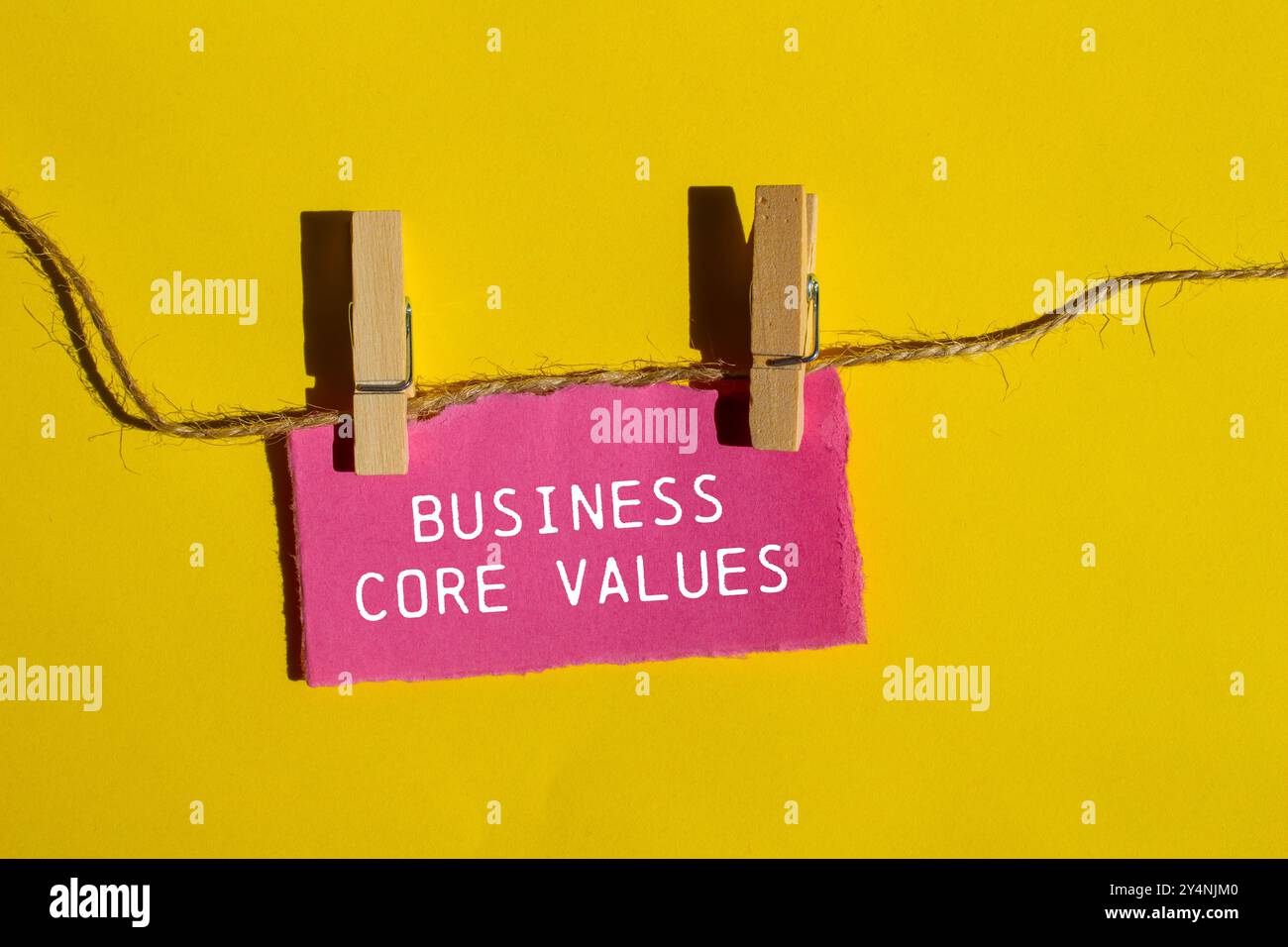 Business core values message written on ripped pink paper piece with ...