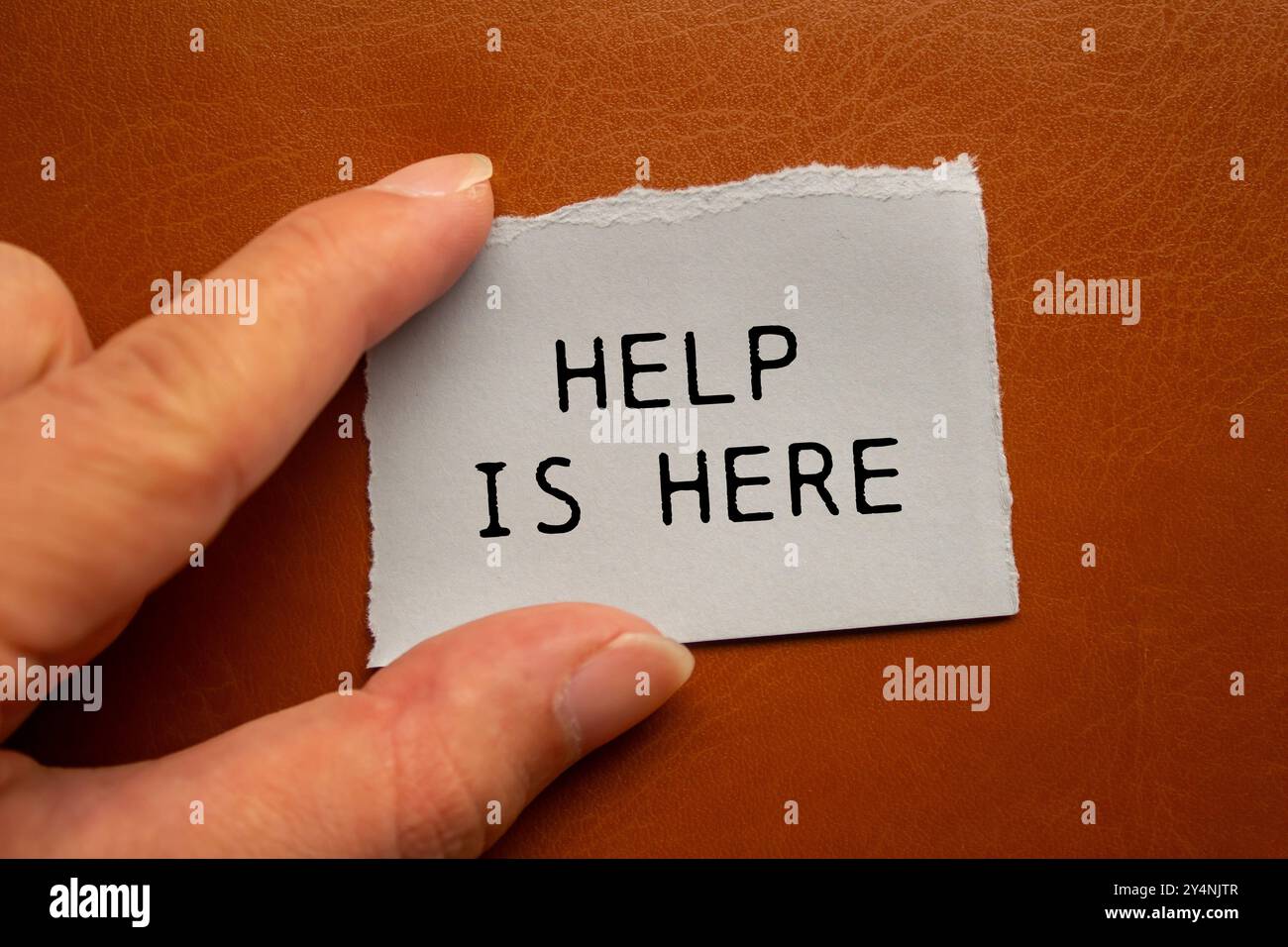 Help is here message written on ripped torn paper piece on brown ...