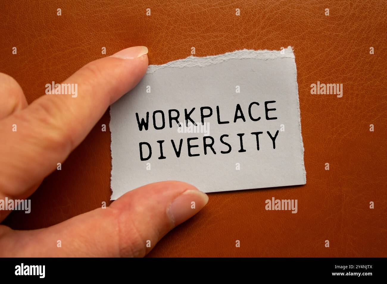 Workplace diversity message written on ripped torn paper piece on brown ...