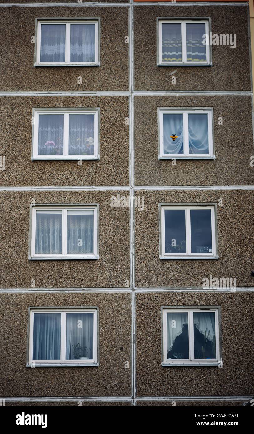 Facade of an apartment building showing multiple windows with curtains ...