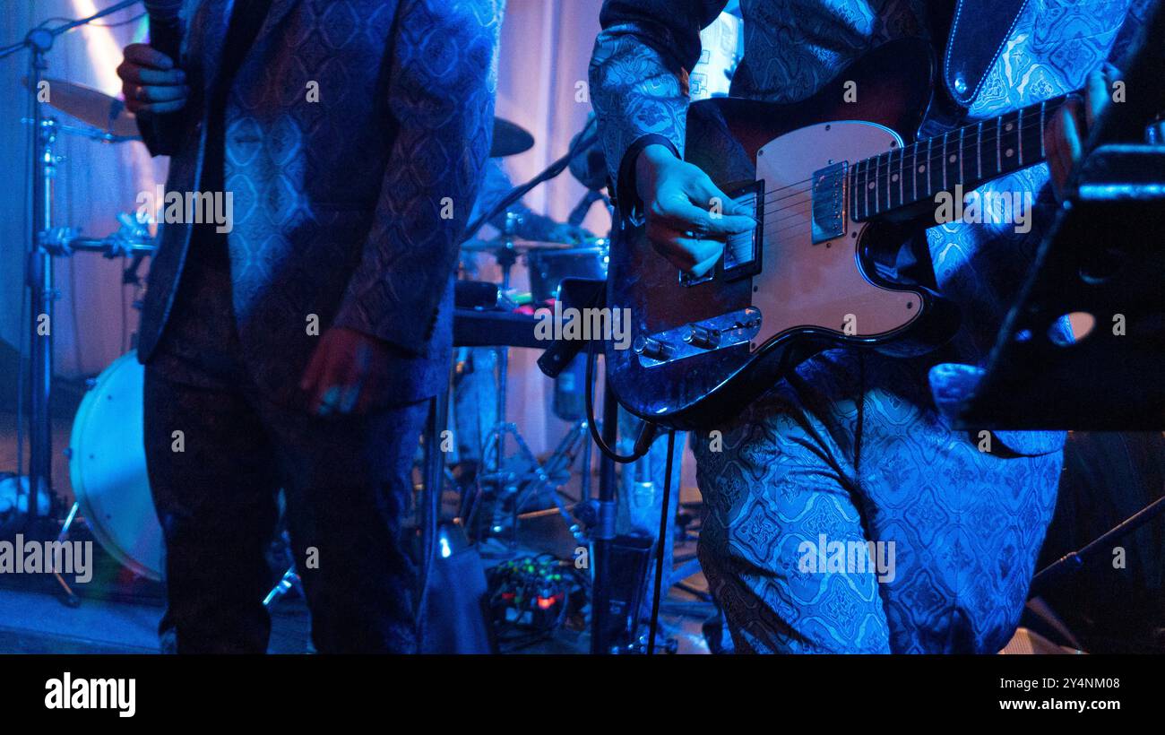 Close up view of guitarist in blue suit playing during a concert at ...