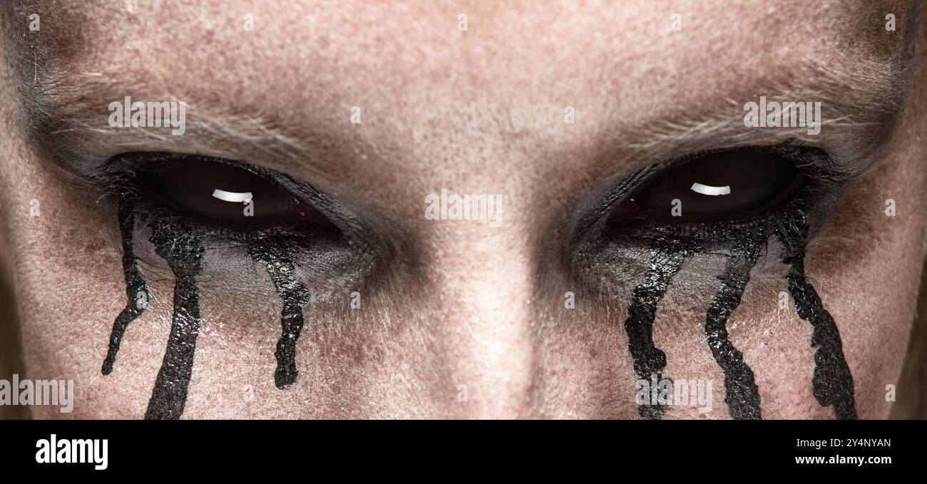 Close-up of haunting, black eyes with dark, teardrop-shaped streaks ...