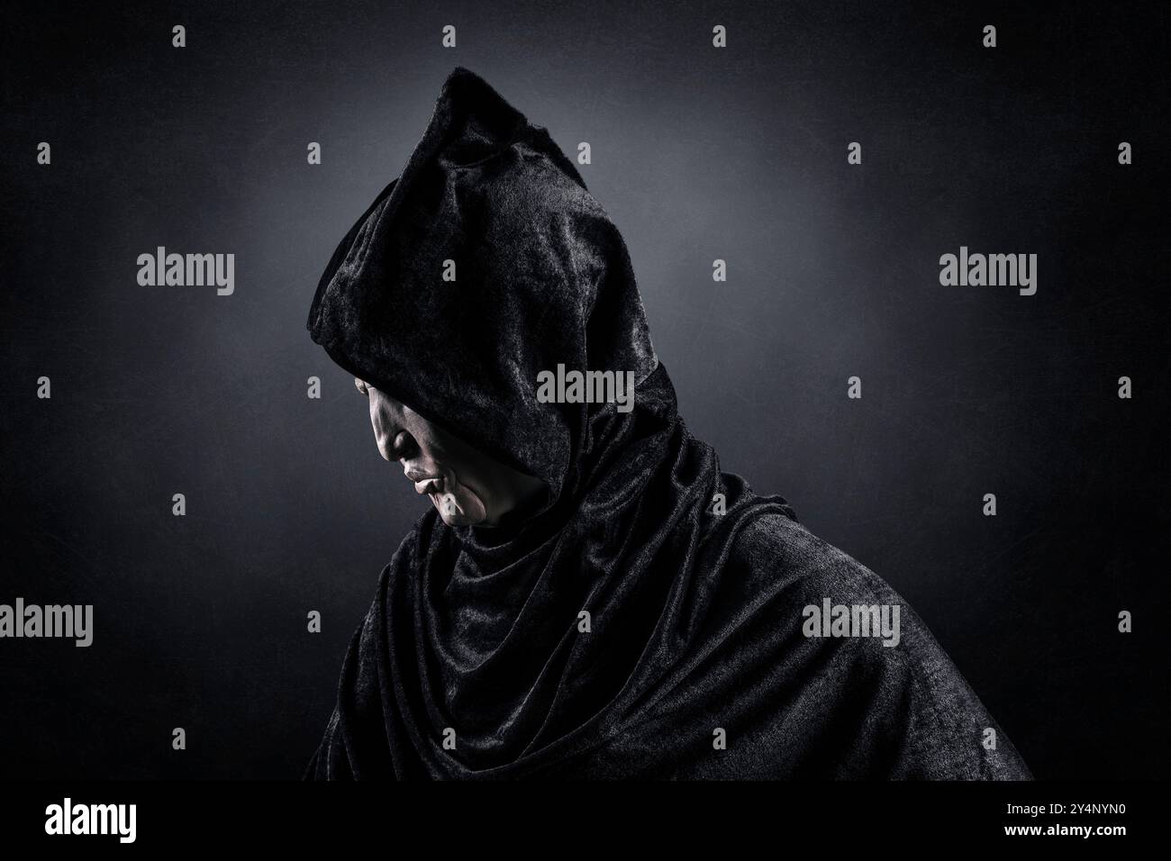Scary figure with hooded cloak in the dark Stock Photo - Alamy