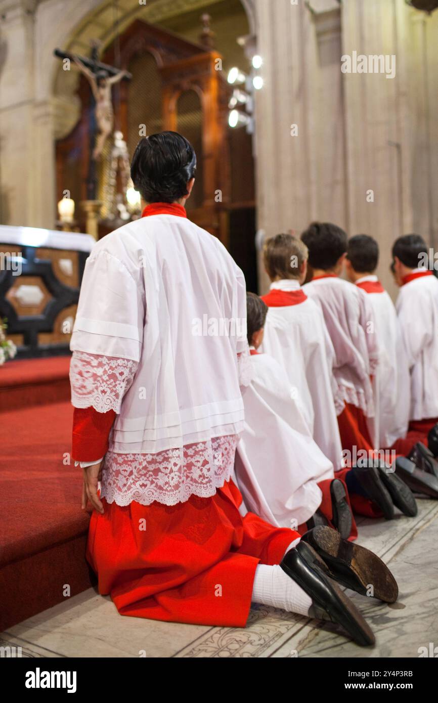 Altar boys kneel in prayer at Sagrario church after the Corpus Christi procession in Seville ...