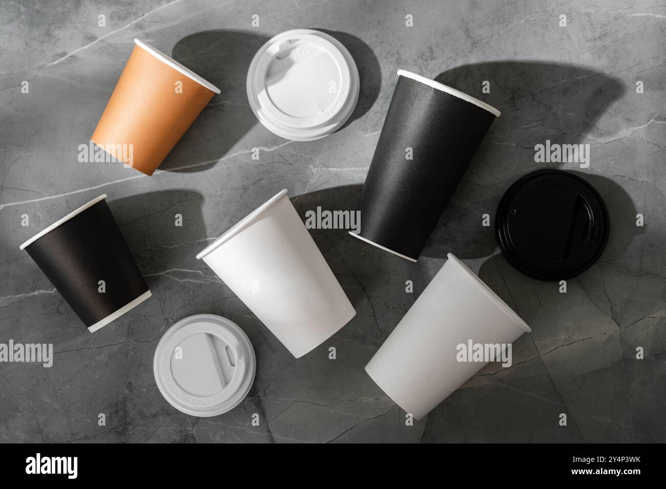 Assorted disposable coffee cups on a textured surface from different ...