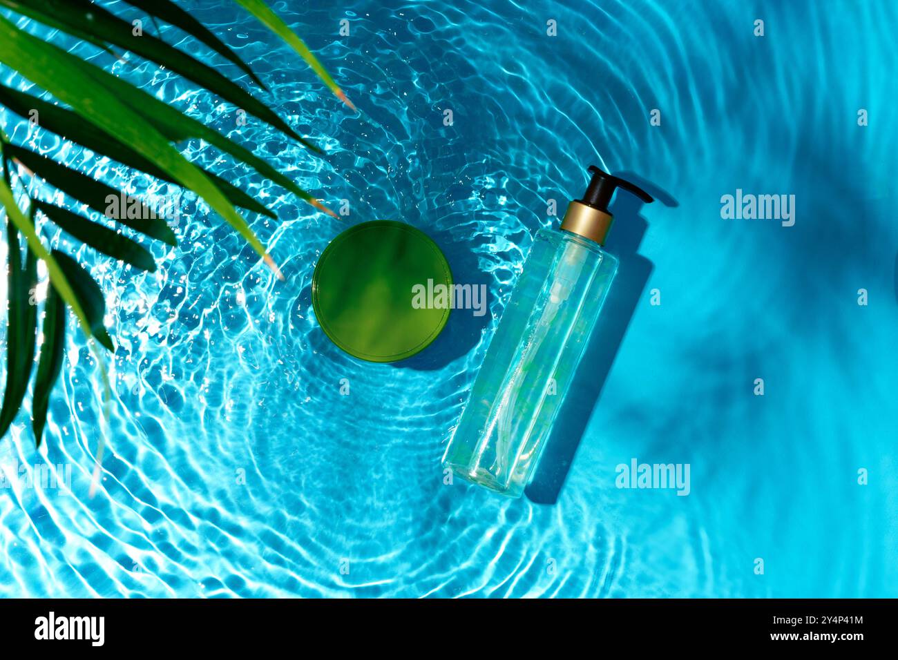 Green bottle floating on a clear blue swimming pool during bright ...