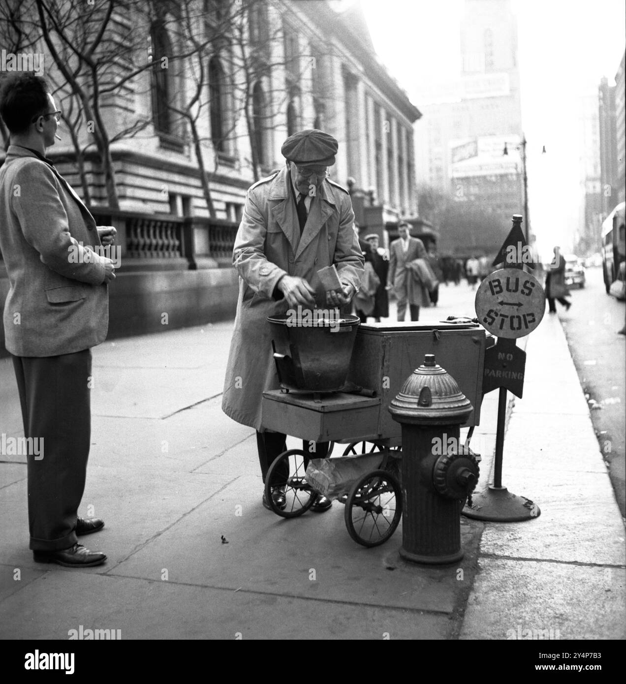 A street vendor sells a lunch to a passerby on a New York City sidewalk ...
