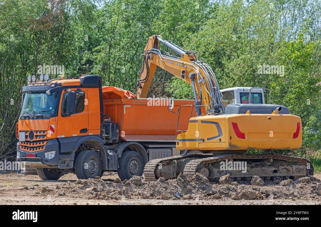 Excavator Digger Loading Dirt in Tipper Truck at Construction Site ...