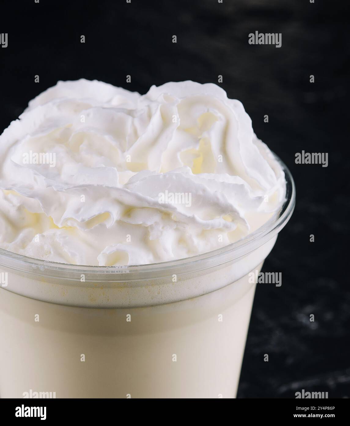 Glass with white milkshake and cream Stock Photo - Alamy