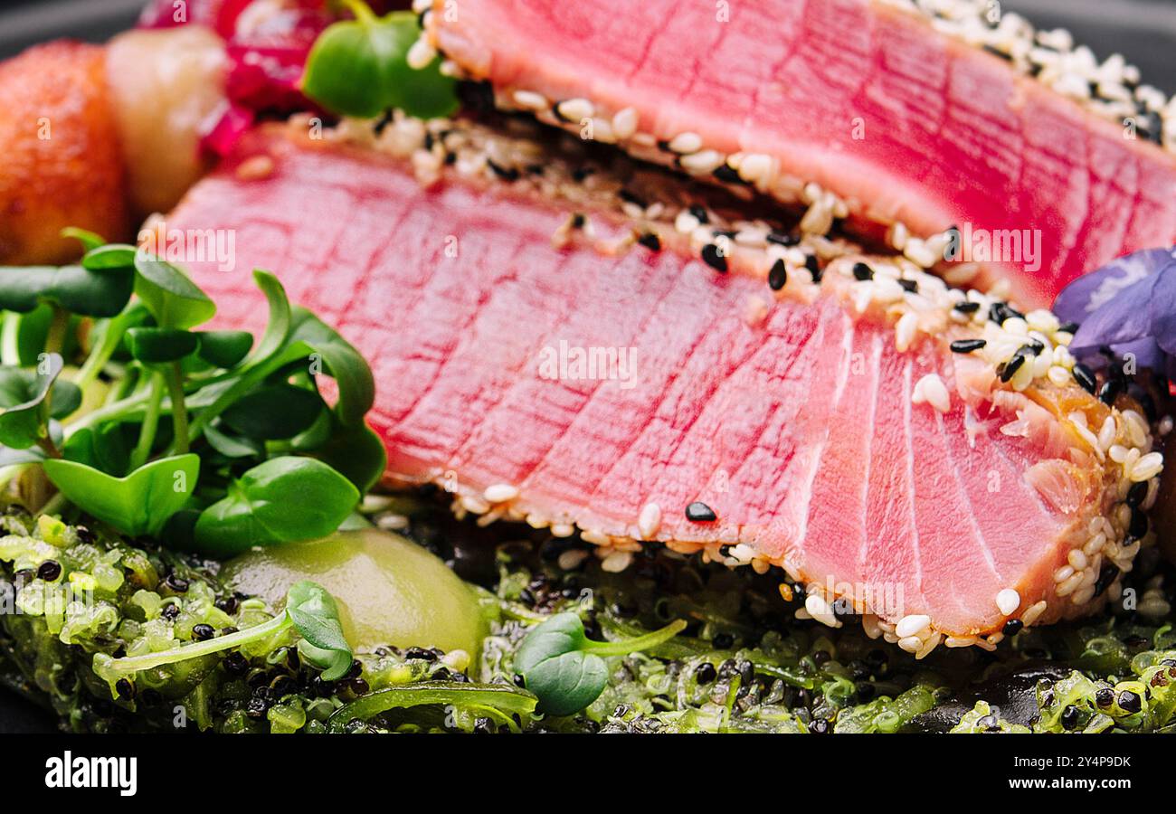 Rare ahi tuna steak slices with fresh herbs macro Stock Photo - Alamy
